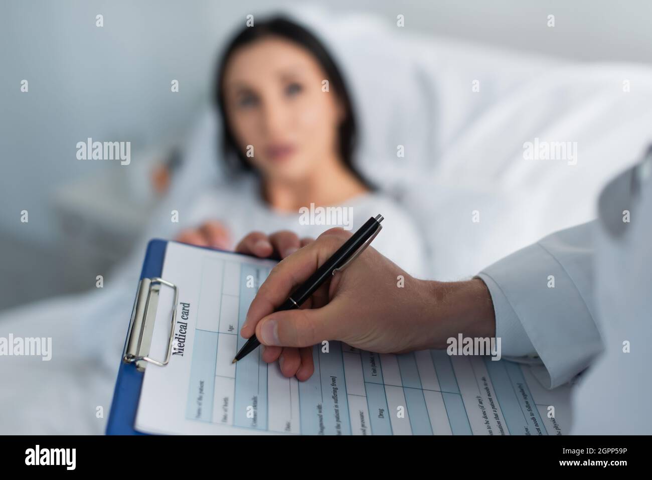 doctor writing prescription on blank near blurred patient Stock Photo ...