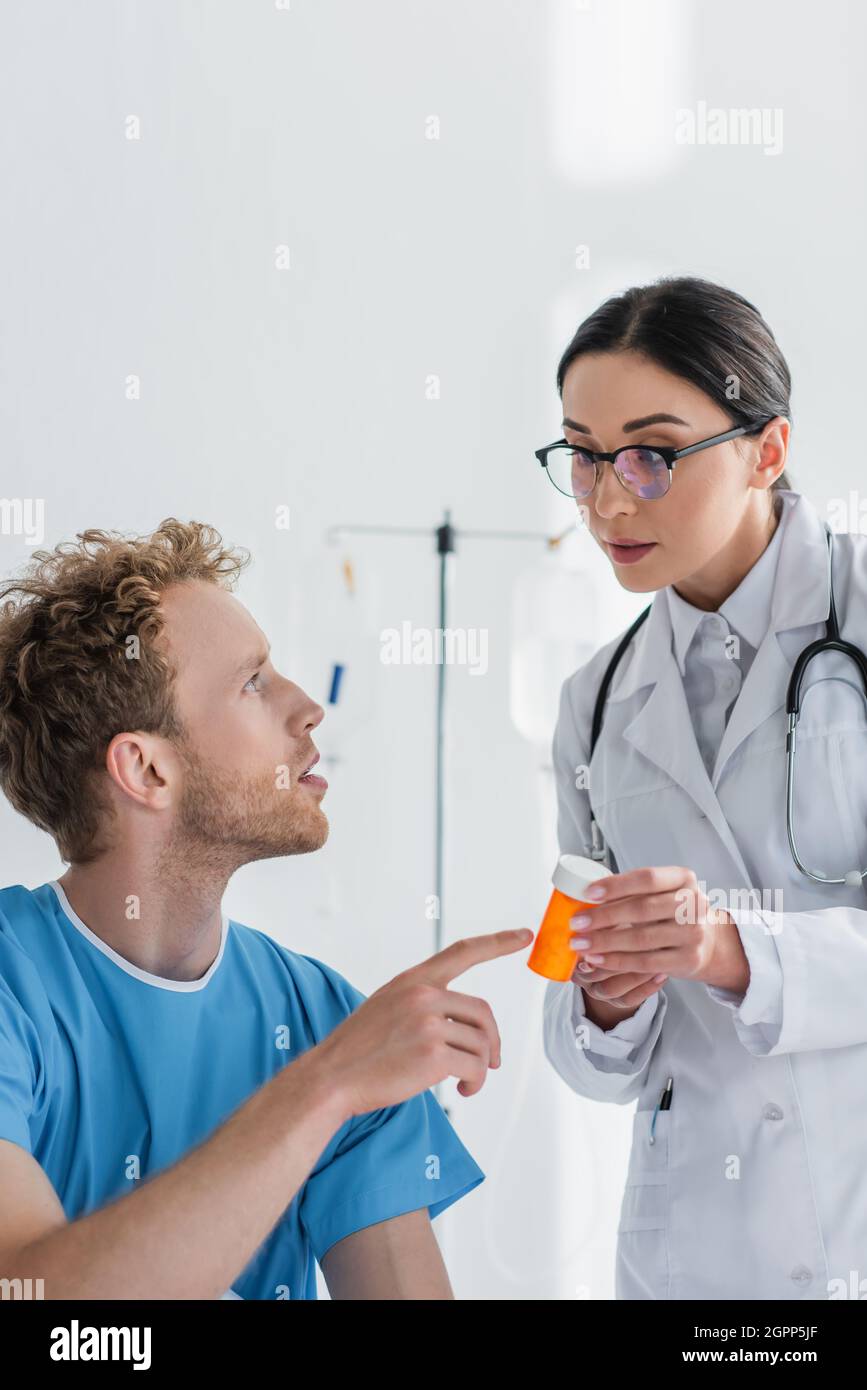 Doctor pointing at medicine bottle hi-res stock photography and images ...
