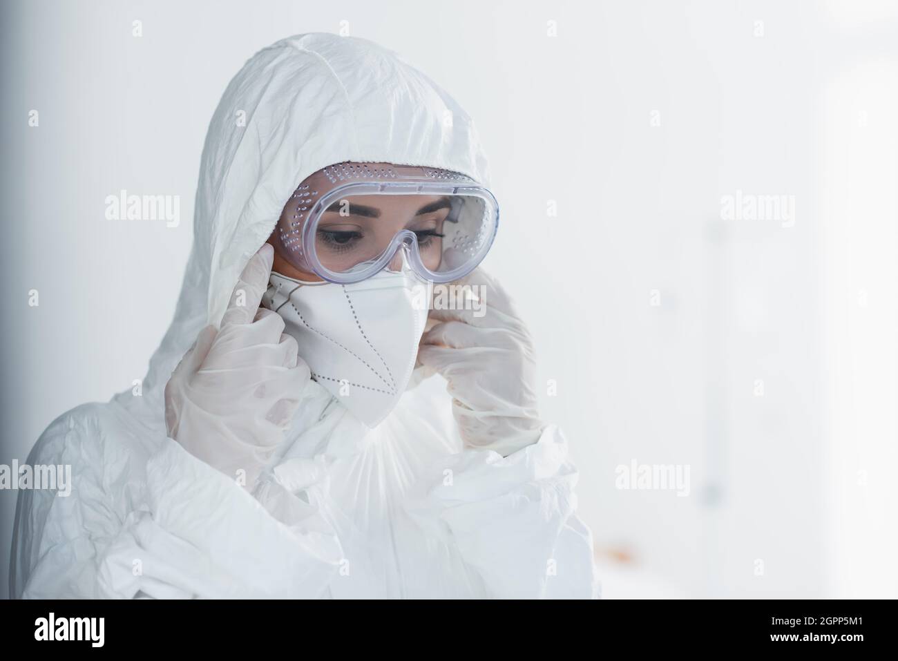 doctor in personal protective equipment and goggles looking down Stock ...