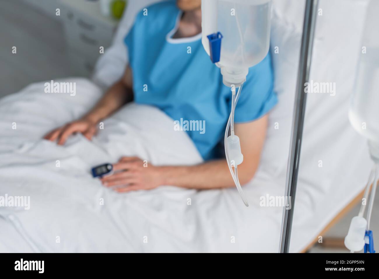 drop counter with intravenous therapy bottle near blurred patient in ...