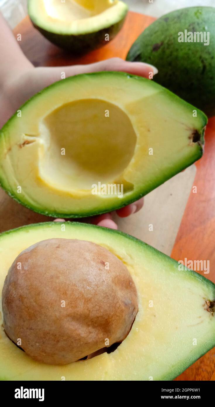 Photo of an avocado split on a table Stock Photo - Alamy