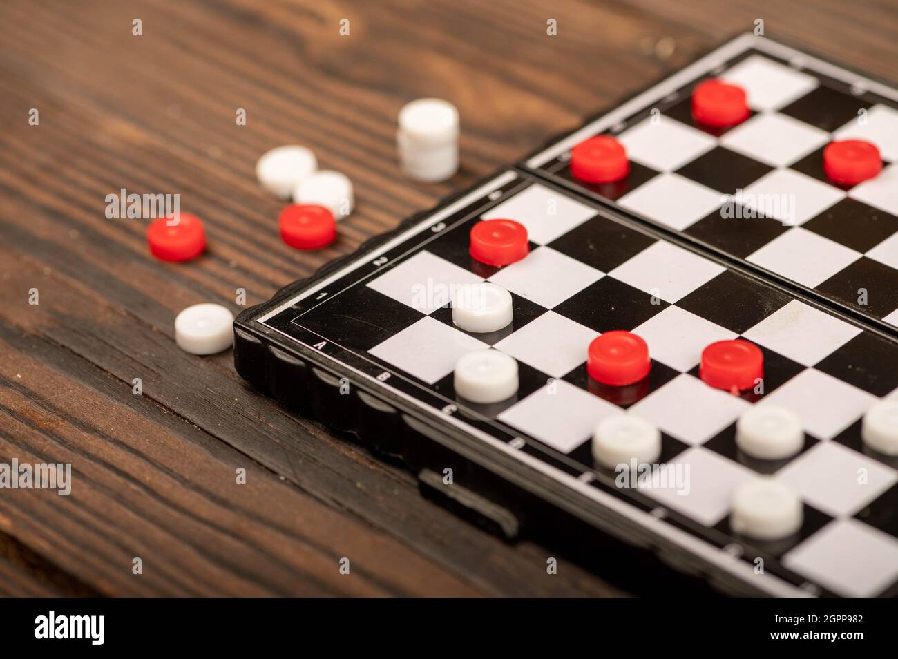 A board for playing checkers with chips on a wooden table, close-up ...