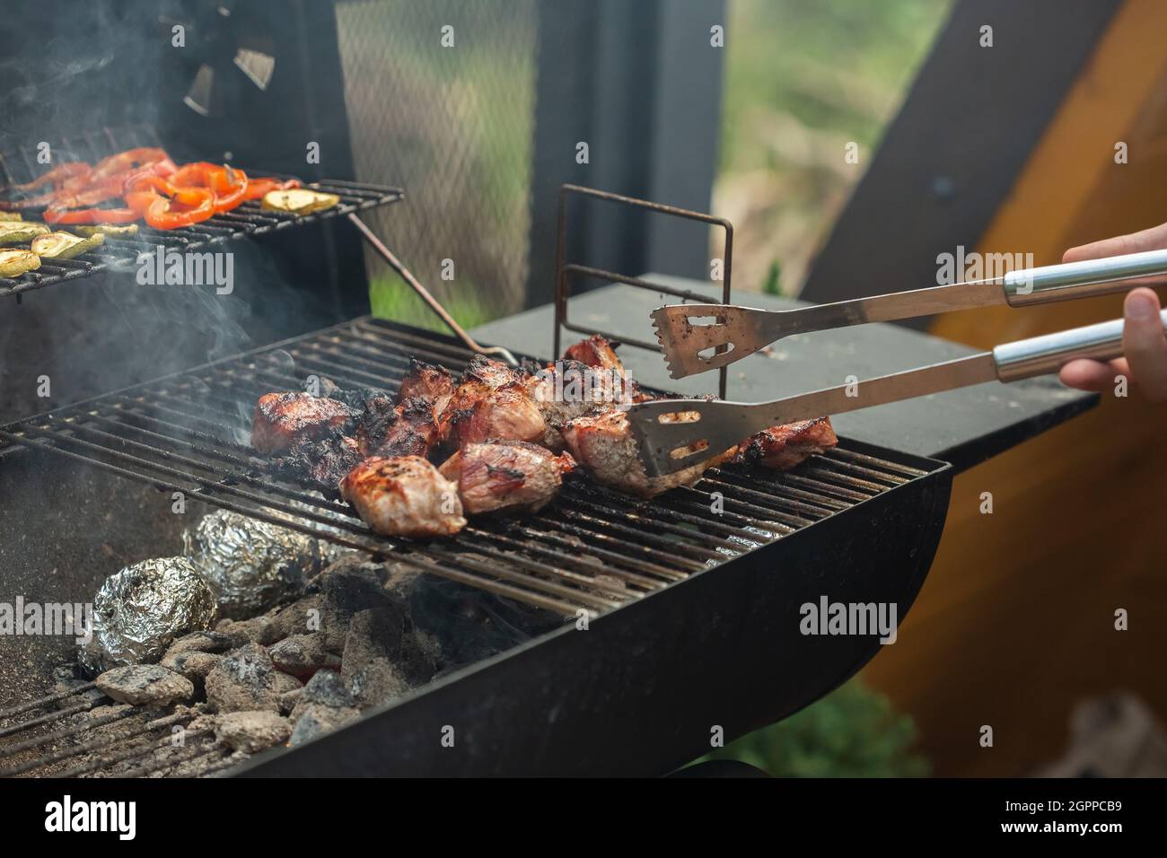 A barbecue grill with tasty juicy steaks are grilled over an open fire ...
