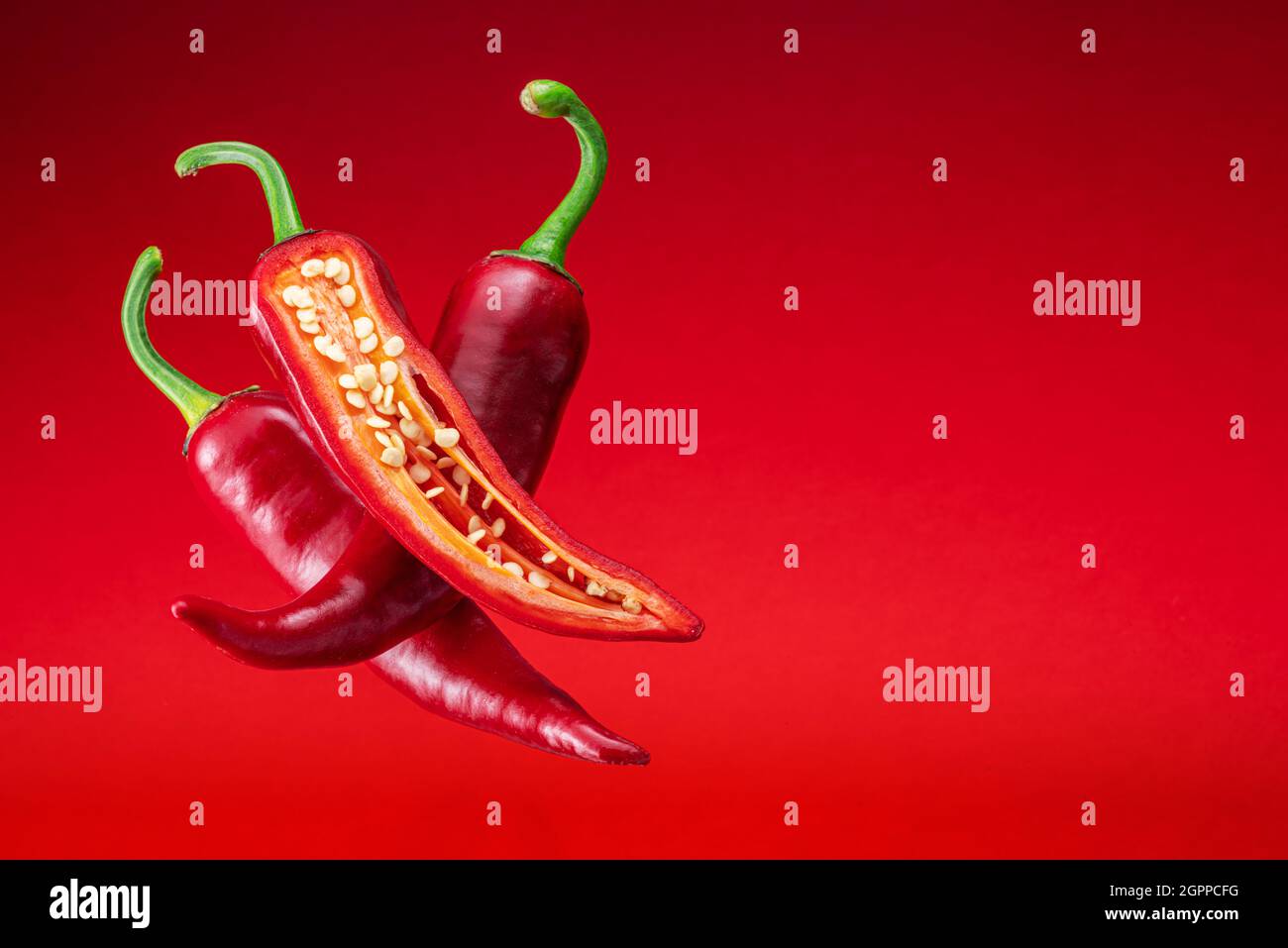 Fresh red chilli peppers and cross sections of chilli pepper with seeds ...