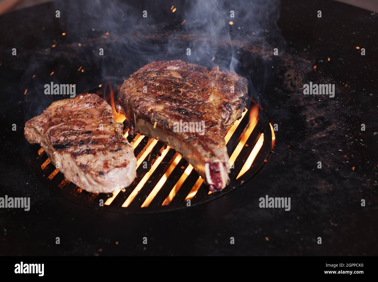 Two steaming beef steaks on grill - cooking process. Top view Stock ...