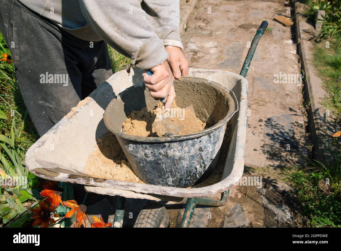 Mixing cement to fill the garden path, garden construction work Stock ...