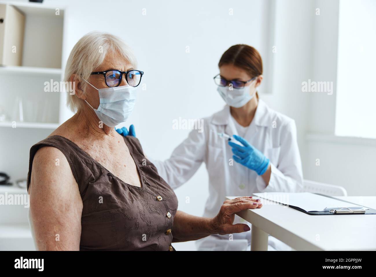 doctor with a syringe makes an injection in the arm immunization safety ...