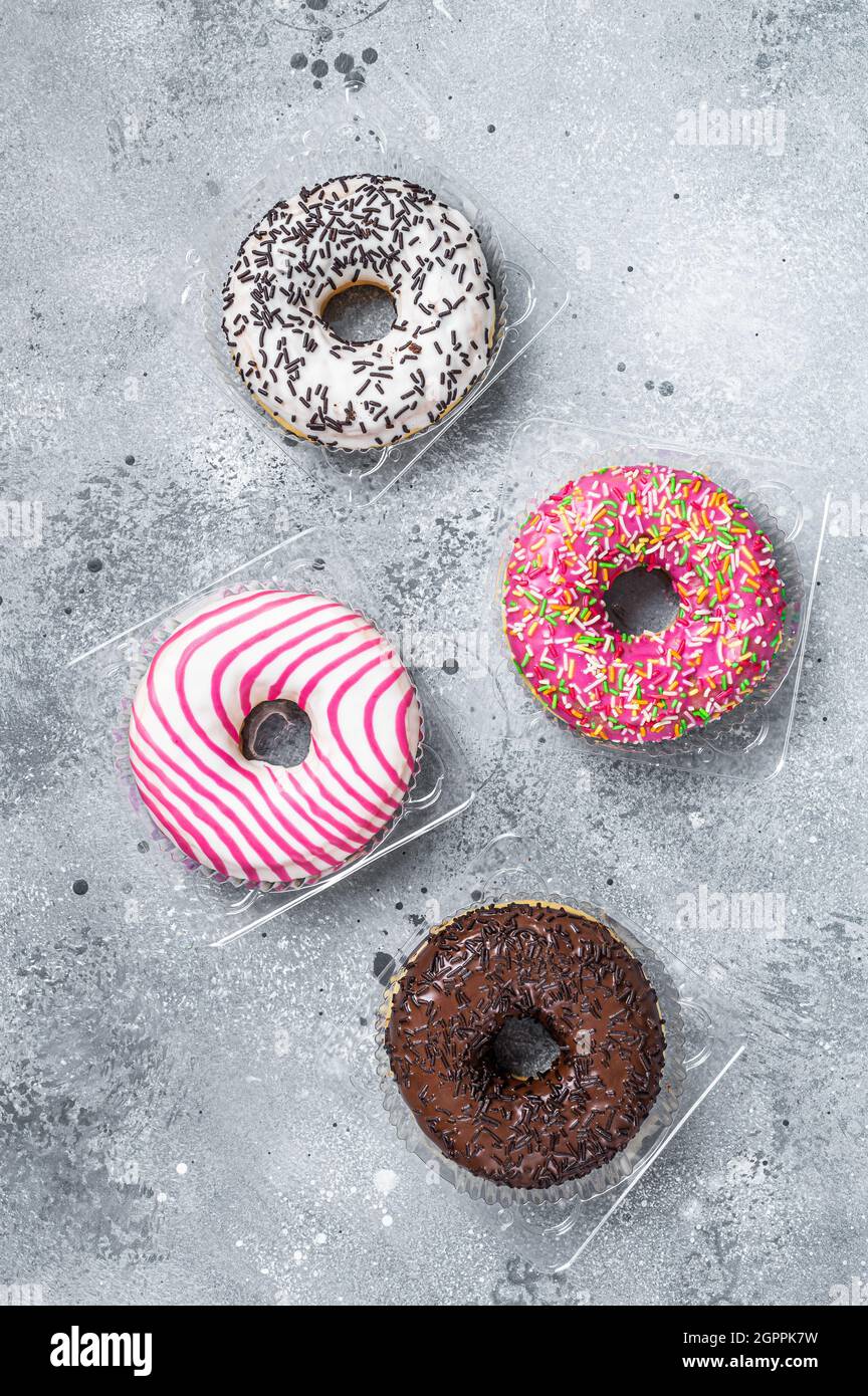 Assorted glazed donuts on a kitchen table. Gray background. Top view ...