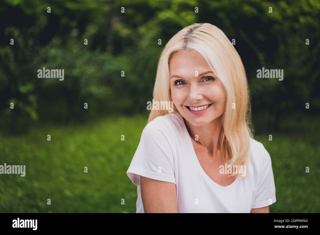 Photo of aged sweet blond lady wear white t-shirt in park alone Stock Photo - Alamy