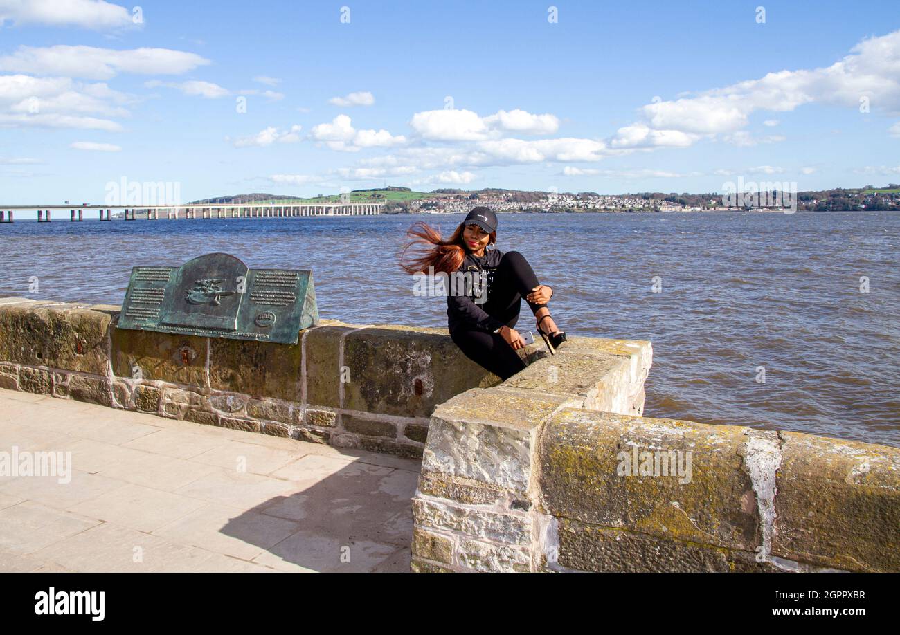A happy African woman is out enjoying the warm sunshine posing for ...