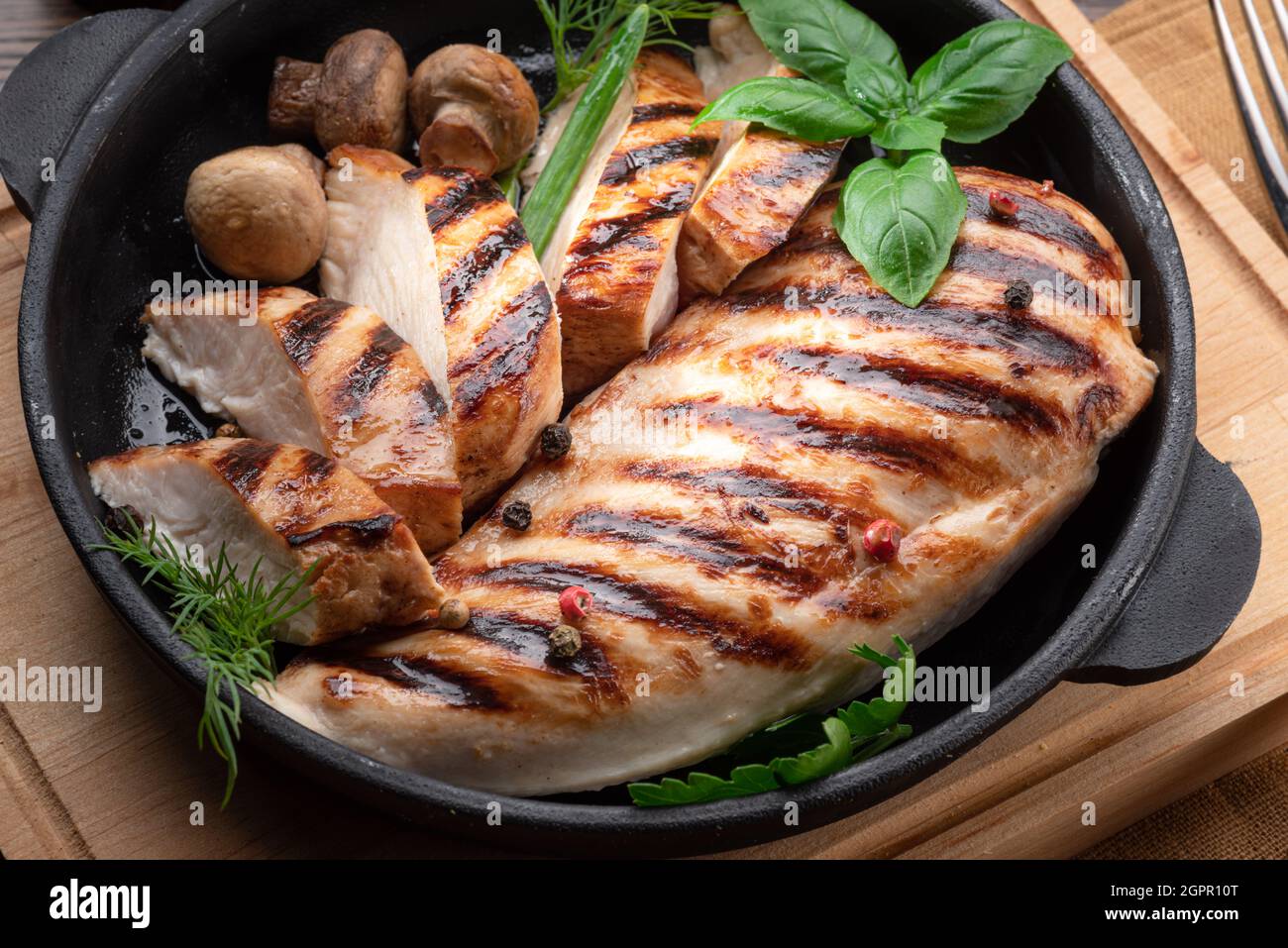 Roasted chicken fillet and mushrooms with herb in the frying pan on the ...