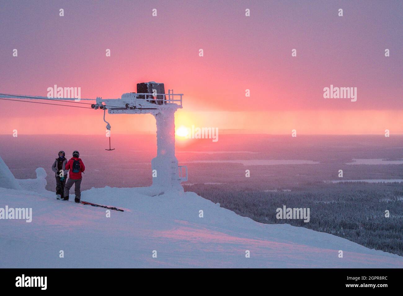 Skiers watching a winter sunset at the Ruka ski resort in Lapland ...