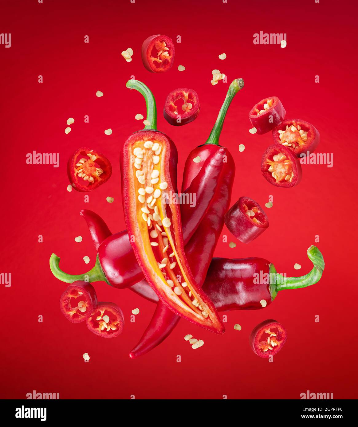 Fresh red chilli peppers and cross sections of chilli pepper with seeds ...