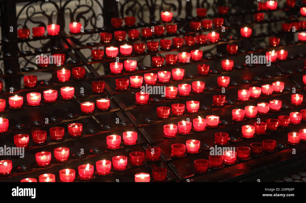 many red votive candles inside the place of worship without people ...