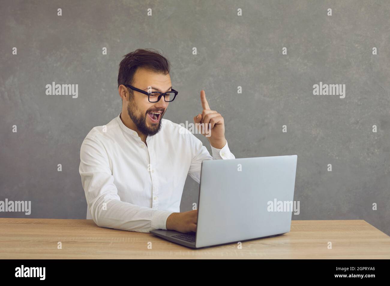 Portrait of happy young man having aha moment while working on his ...