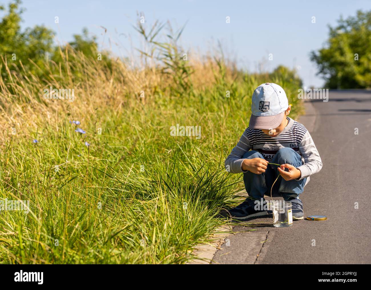 POZNAN, POLAND - Sep 05, 2021: A young boy picking something up from ...