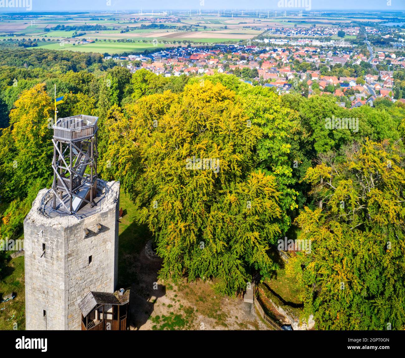 Old castle ruins with a wooden viewing platform in front of a dense ...