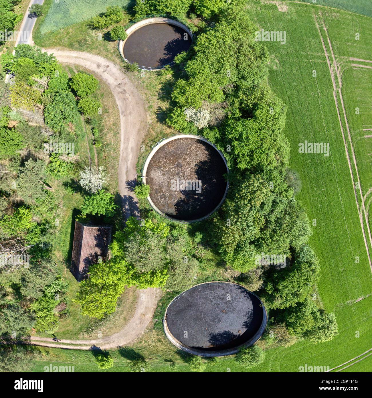 Aerial view of three circular slurry ponds for fertilization next to a ...