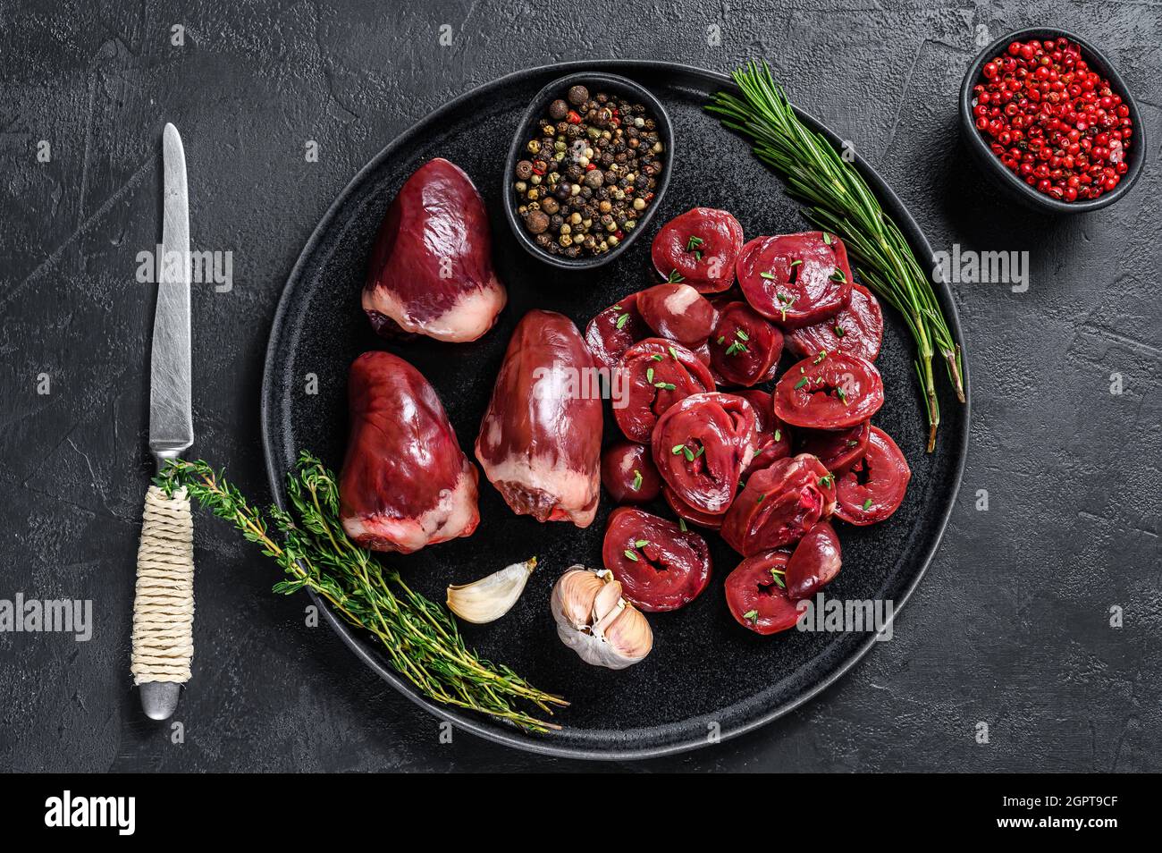 Sliced Raw turkey hearts ready for cooking. Black background. Top view ...