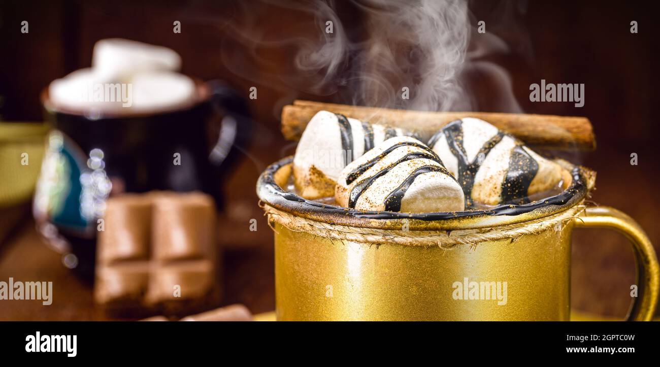 hot chocolate with steam or smoke in a golden cup with marshmallows and ...