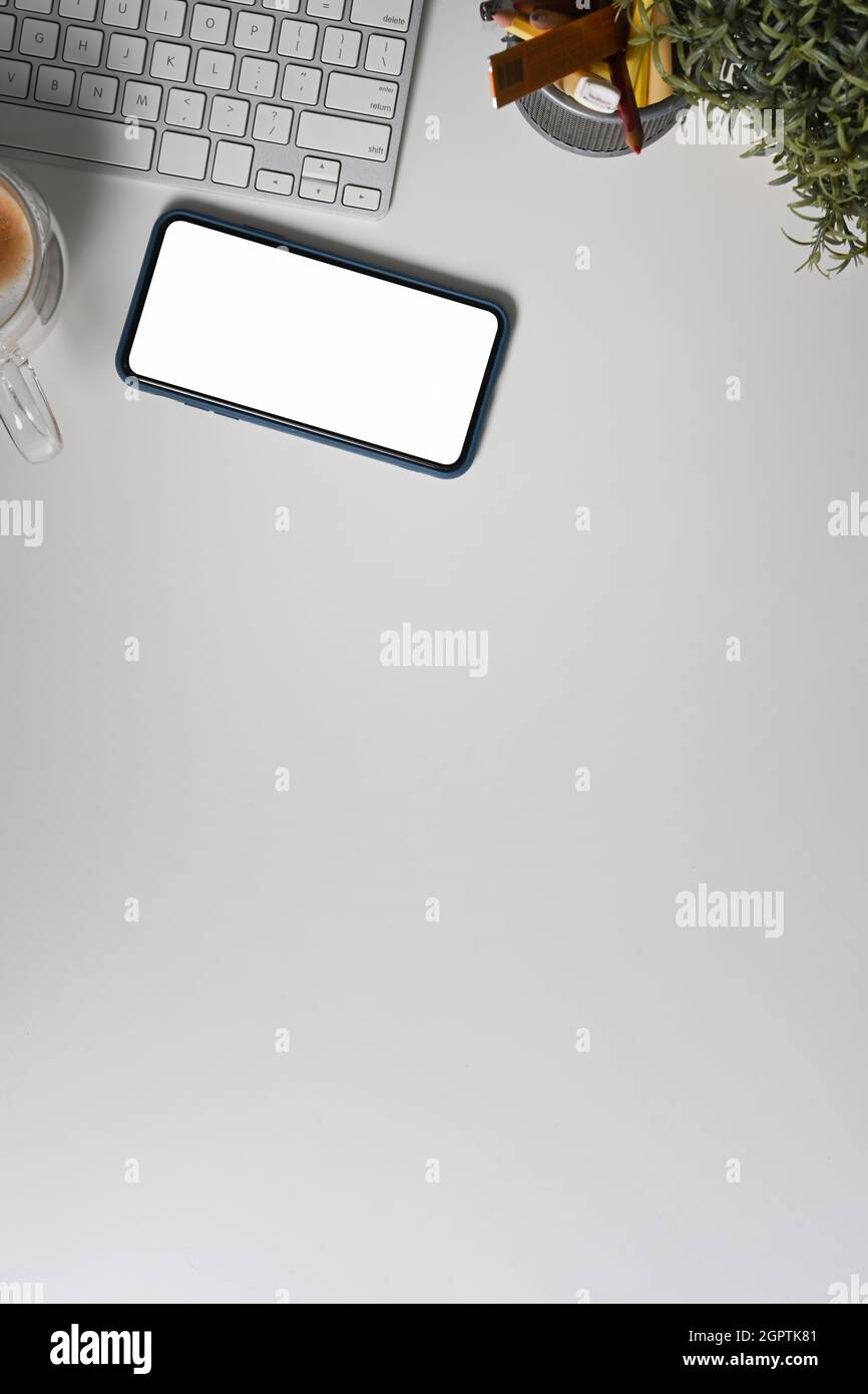 Above view smart phone with empty screen on white office desk Stock ...