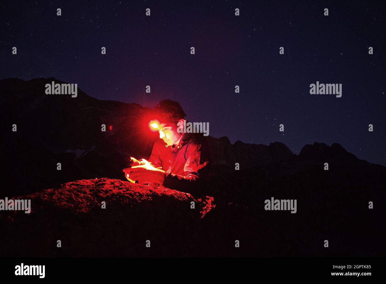 Male with a red light on his head taking photos of the night sky and ...