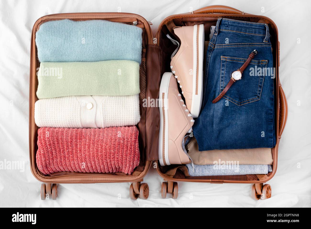Opened luggage with folded clothes and shoes Stock Photo - Alamy