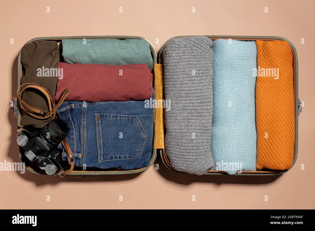 Opened luggage with clothes folded and camera Stock Photo - Alamy