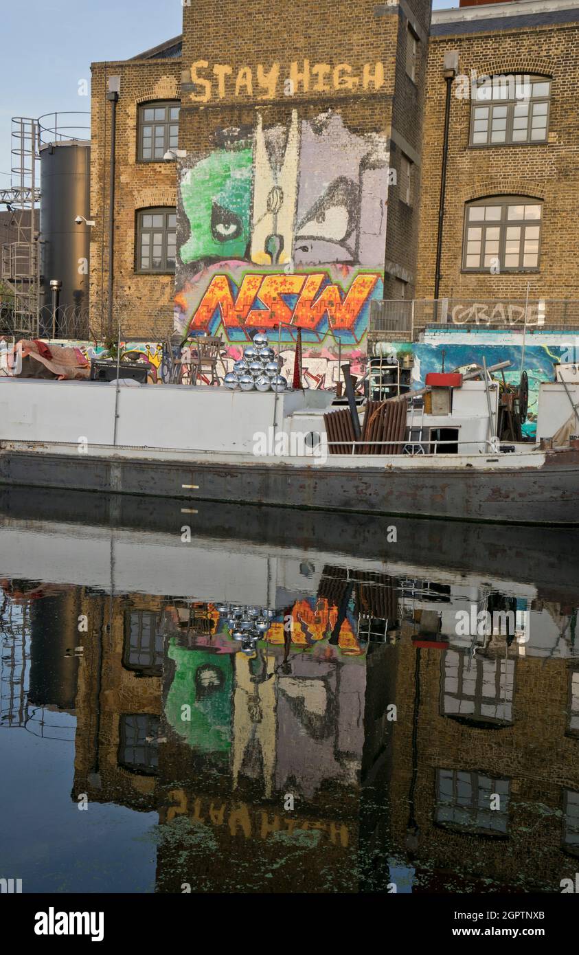 Old pub and warehouse studios by the Lea river canal with graffiti art ...