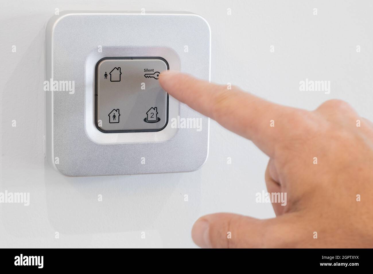 hand activates burglar alarm on the wall Stock Photo - Alamy