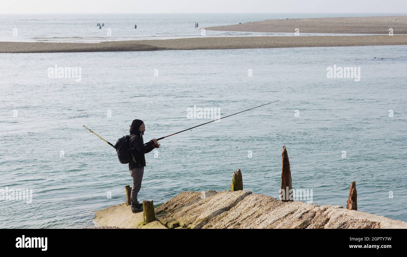 Angler seen beach fishing in Pagham, UK Stock Photo - Alamy