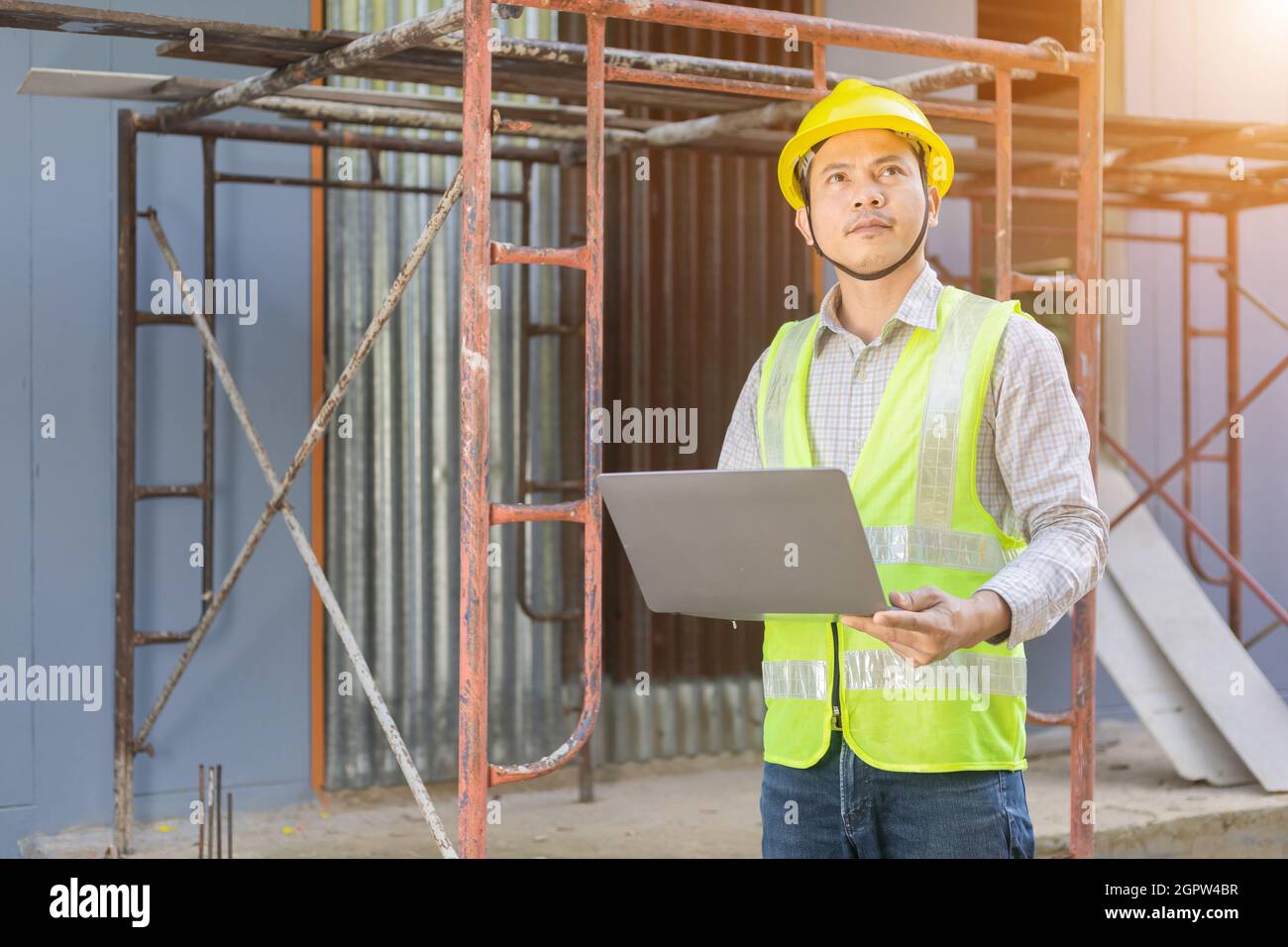 A male engineer looks at the floor plan at the construction site Stock ...