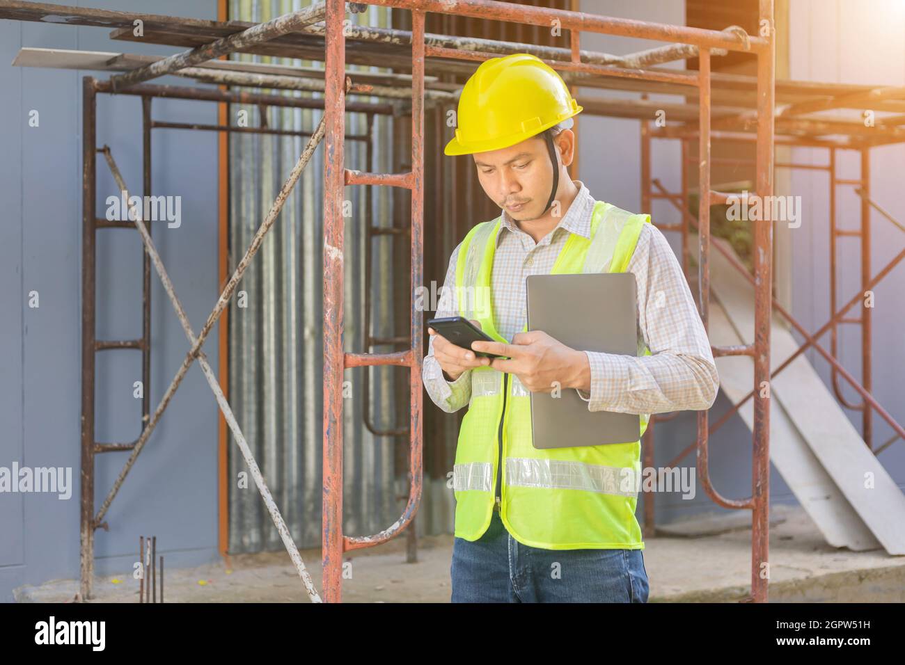 A male engineer looks at the floor plan at the construction site Stock ...