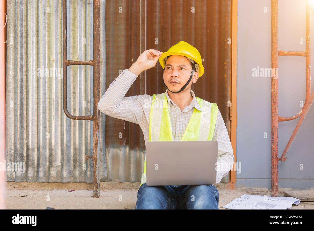 A male engineer looks at the floor plan at the construction site Stock ...