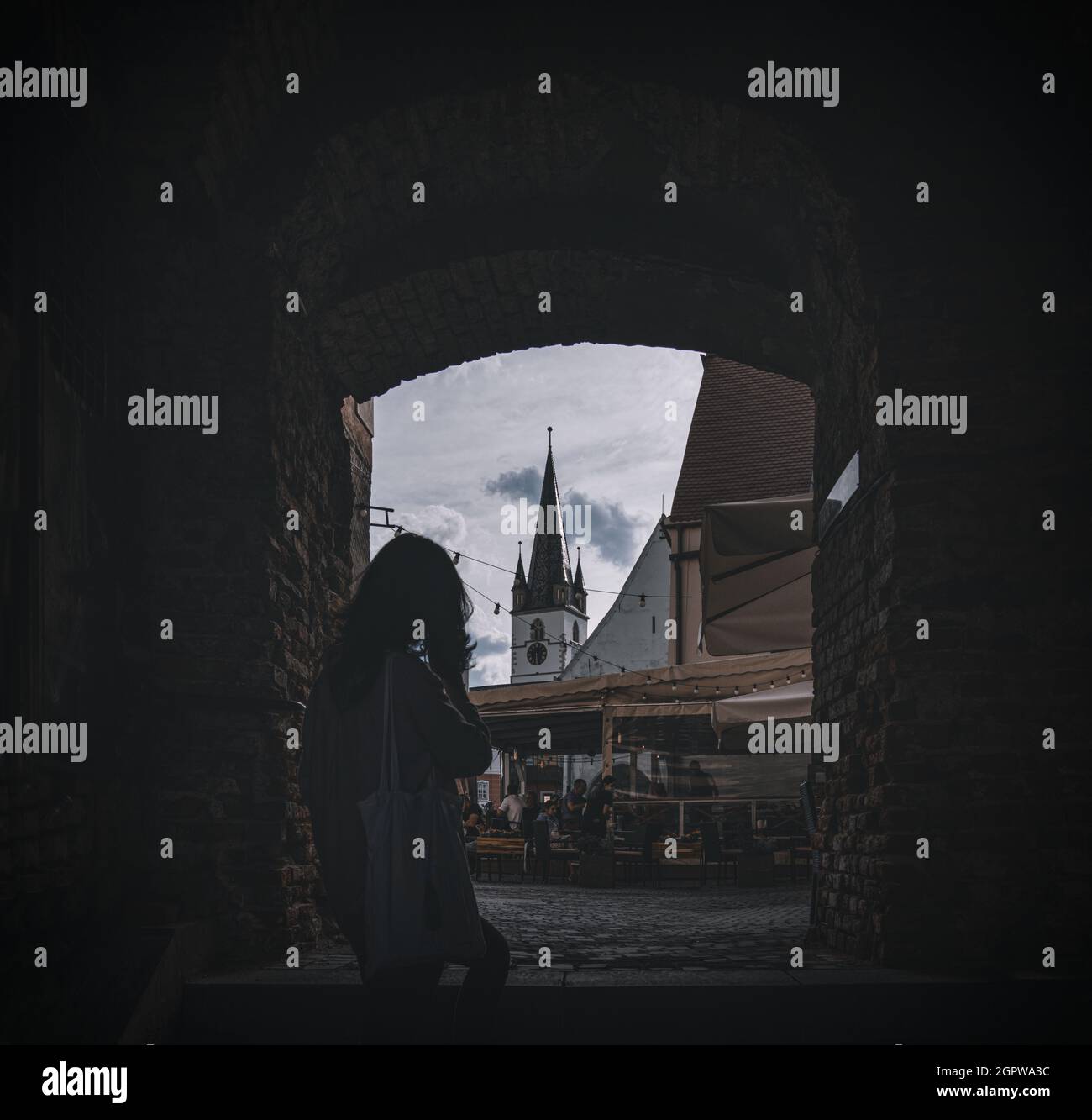 Back view of a female standing under the arch on a cathedrbackground in ...