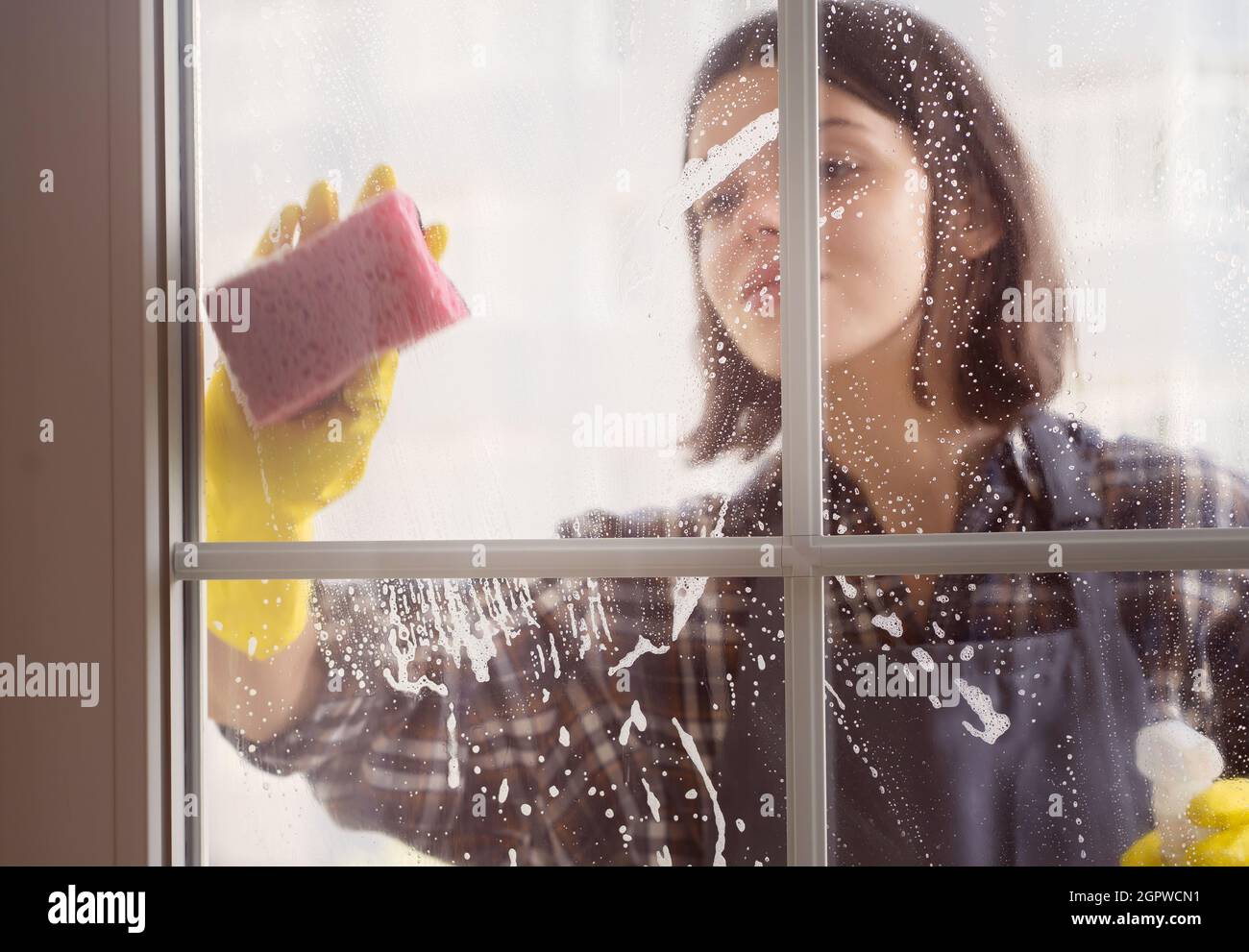Woman washes the windows with a detergent Stock Photo - Alamy