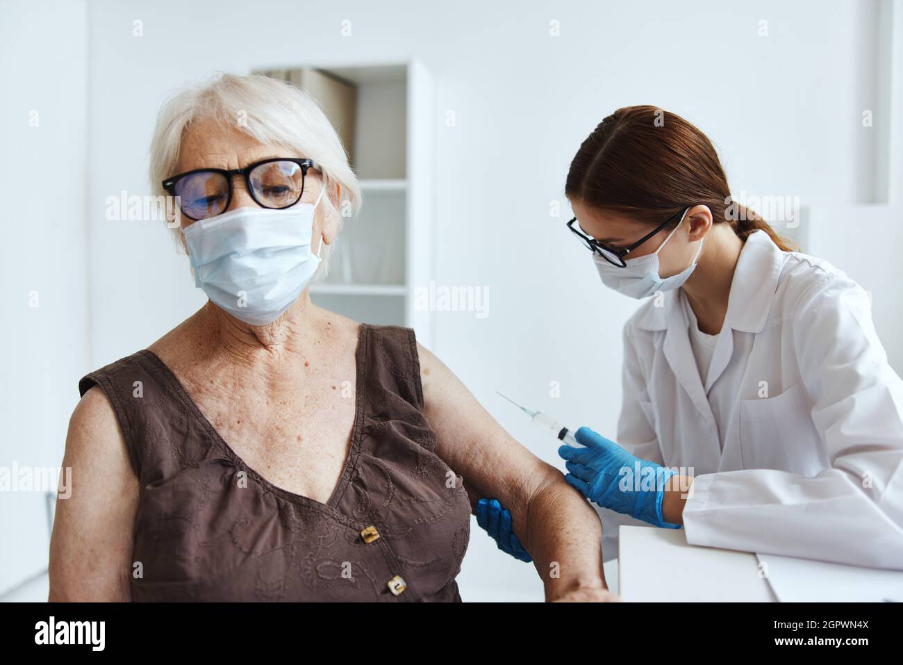 elderly woman wearing a medical mask next to the doctor immunity ...