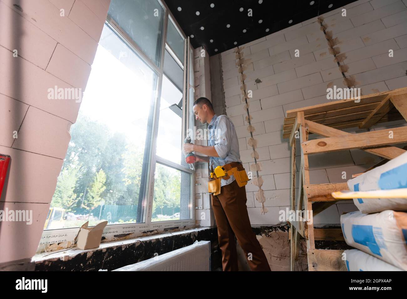 Construction worker installing window in house Stock Photo - Alamy