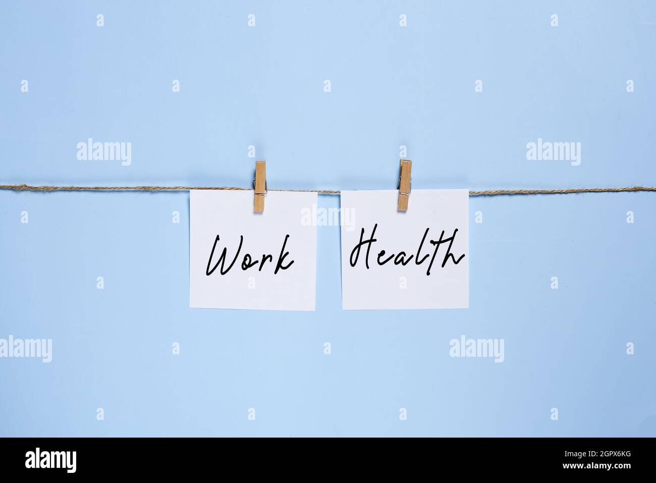 Two pieces of paper with work and health words hanging on a rope on the ...