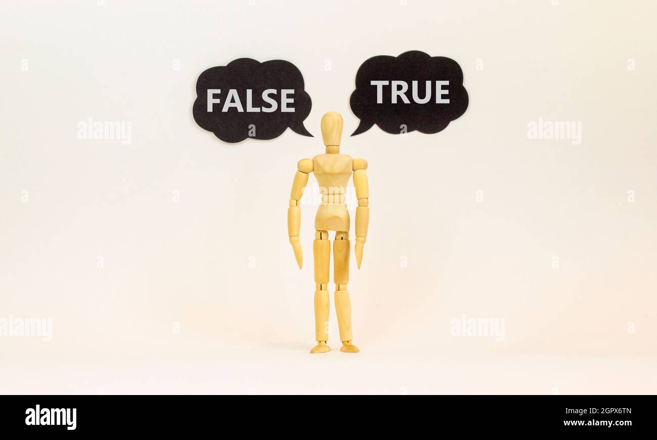 True or false symbol. Wooden model of businessman human. Black paper ...