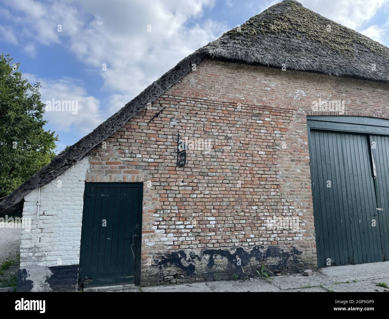 Triangle-shaped brick building in the village with big black doors ...
