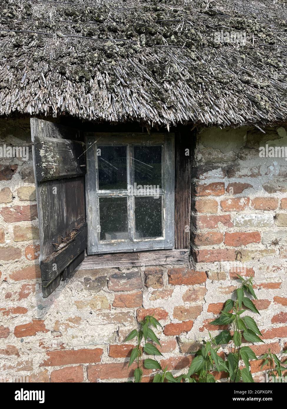 Closeup shot of a rural brick home with a small wooden window and ...