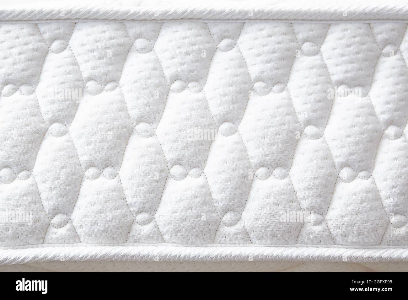 Large white mattress with stitched finishing lines. Close-up. Side view ...