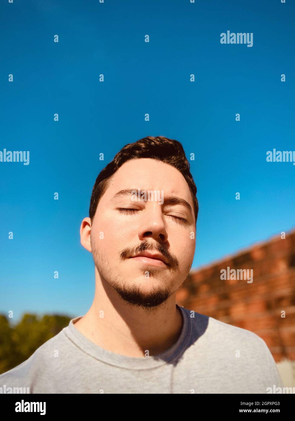 Young Man In The Sun With Blue Sky Stock Photo - Alamy