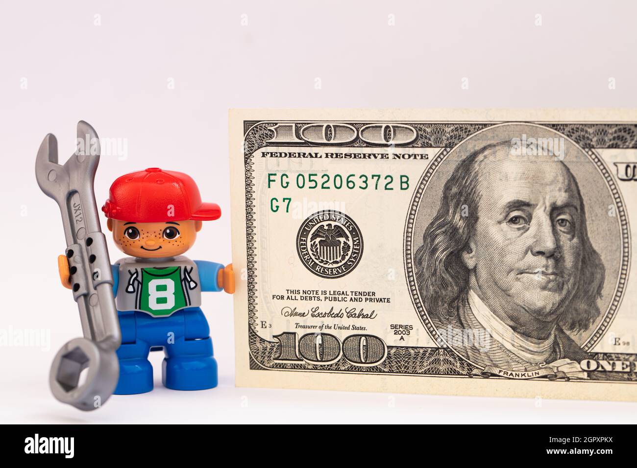 Small man figurine with 100 dollar banknote for design purpose Stock ...