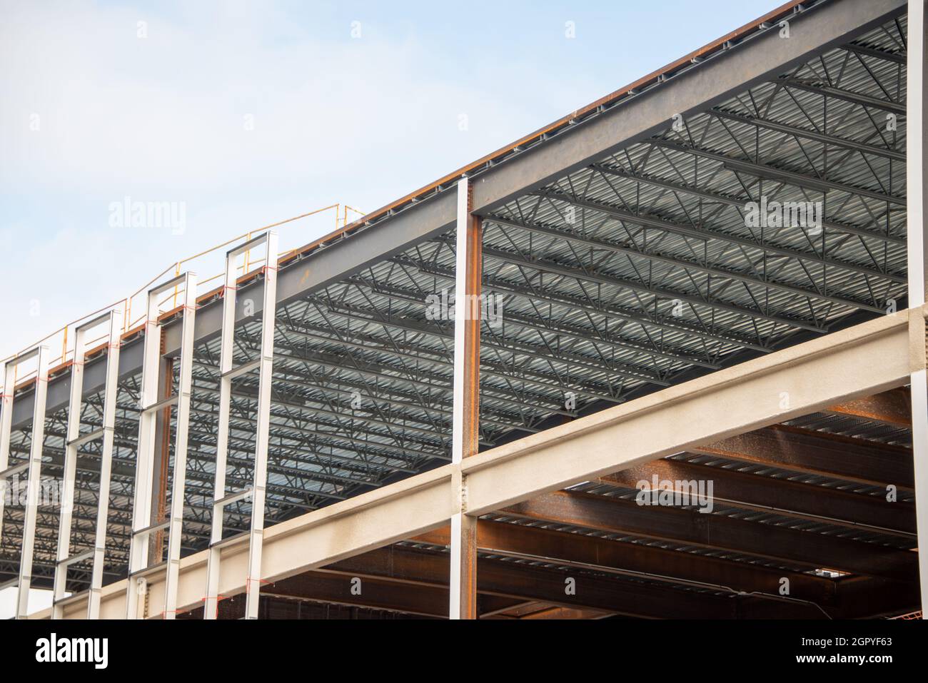 A large multiple story metal building wall with steel beams against a ...