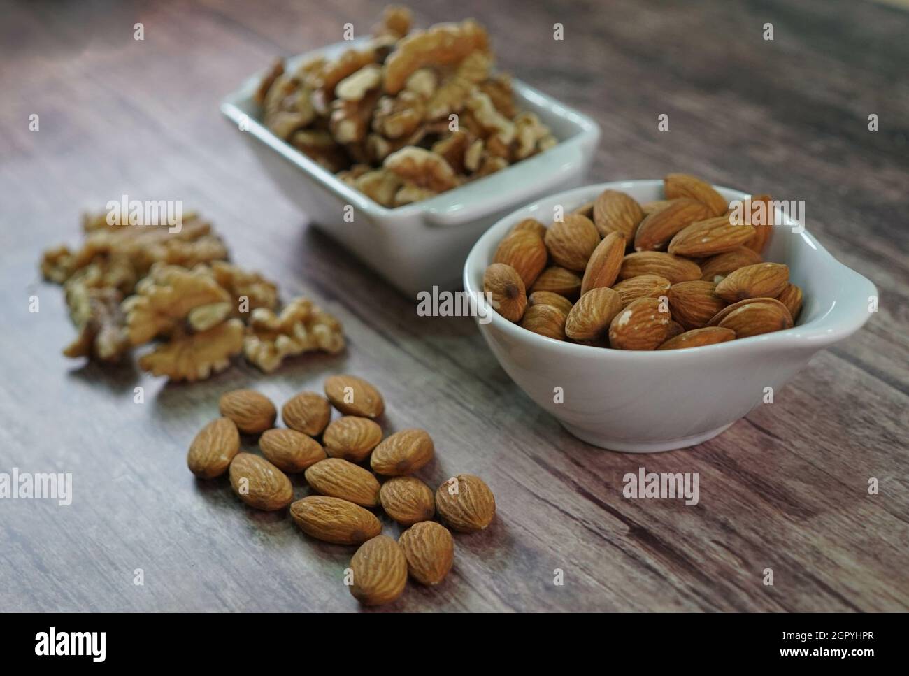 Walnuts and Almonds in white bowls Stock Photo - Alamy
