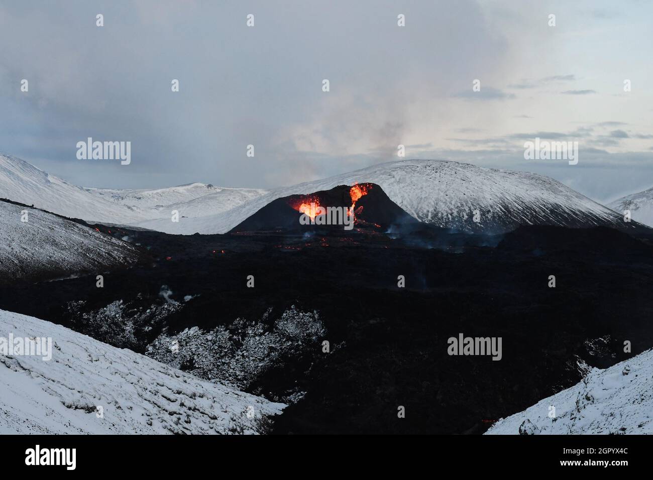 Eruption at Fagradalsfjall volcano, Iceland. Black lava field framed by ...