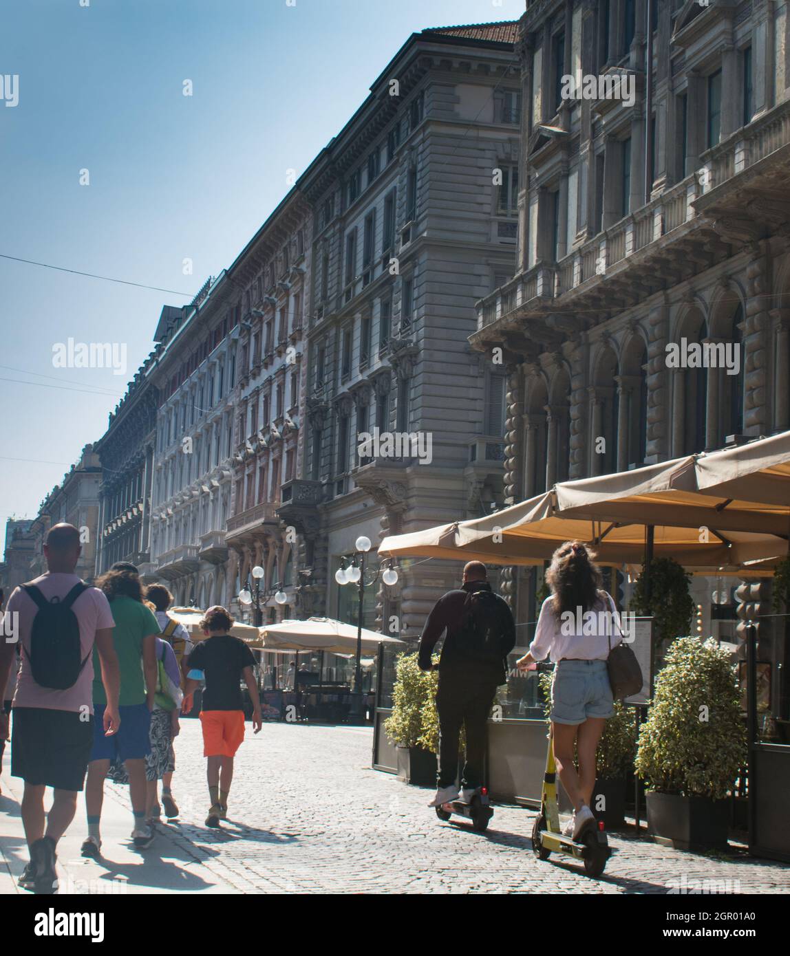 Tourist walking down a popular Italian market street with cafes and ...