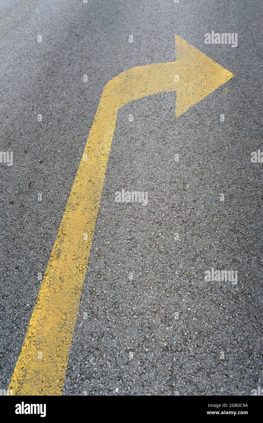Yellow direction sign pointing to the right on the ground Stock Photo ...